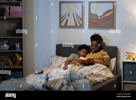 Vorsichtige Junge Afroamerikanische Mutter Die Mit Dem Sohn Im Bett