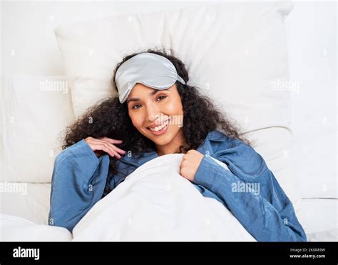 A Young Multi Ethnic Woman Stretches With Arms Behind Head And Sleep
