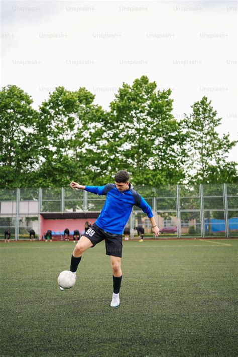 フィールドでサッカーボールを蹴る若い男の写真 練習 Unsplashの写真