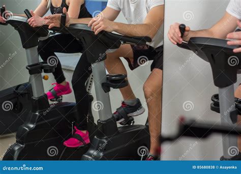 Hombre Joven Y Mujer Biking En El Gimnasio Ejercitando Las Piernas Que