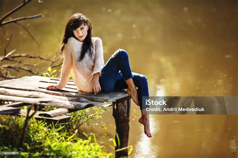 맨발로 오래된 다리에 앉아있는 젊은 여성 여름 녹색 숲 호수와 저녁에 공기는 휴식 명상 자연의 소리와 꿈의 소리를 즐길 수있는