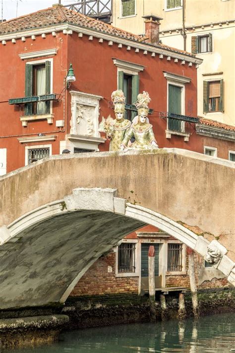 Small Bridge Over A Canal In Venice With A Couple In Costume During The