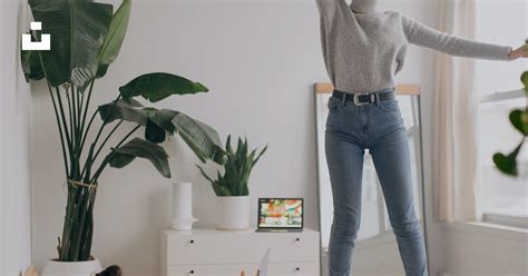 흰색 긴 소매 셔츠와 파란색 데님 청바지를 입은 사람이 흰색 침대에 서 있다 사진 Unsplash의 무료 사람 이미지