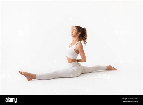 Young Woman Practicing Yoga Doing A Variation Of The Hanumanasana