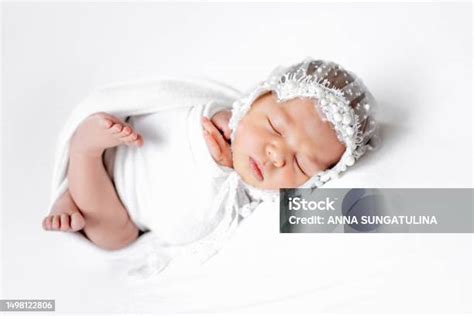 기저귀를 차고 하얀 바탕에 아름다운 모자를 쓴 갓 태어난 여자 아기가 달콤하게 자고 있고 아기가 태어나고 행복한 가정이 있습니다 1개월에 대한 스톡 사진 및 기타 이미지