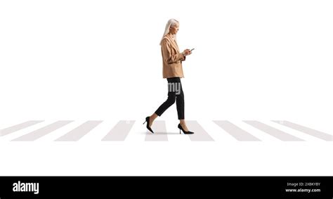 Professional Woman Walking At Pedestrian Crossing And Typing On A