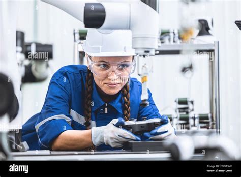 engineer woman worker working with robotic arm in productions lab
