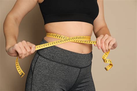 베이지 색 배경에 테이프로 허리를 측정하는 여성 클로즈업 가냘픈에 대한 스톡 사진 및 기타 이미지 가냘픈 건강한 생활방식