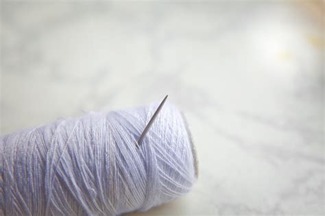 흰색에 고립 된 바늘흰색 보빈 자수 바늘로 바느질 실을 닫습니다 공예 및 Diy 개념 흰색 스레드 흰색 배경에 바늘입니다 공예에