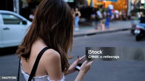 여 자가 걸어와 카오산 로드 태국 방콕에 저녁에 거리를 걸어에 스마트 전화에 문자 메시지 여성 여행자와 관광 개념입니다 20