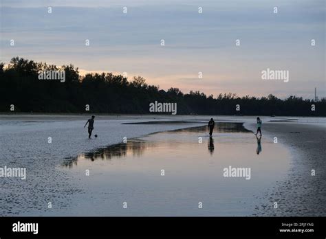 Malaysian Domestic Tourists Play Football At Sunset On A Beach In