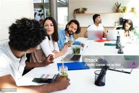 다인종 동료 그룹은 사무실 테이블에서 점심 시간을 보내고 다른 동료들은 뒤에서 일합니다 5명에 대한 스톡 사진 및 기타 이미지