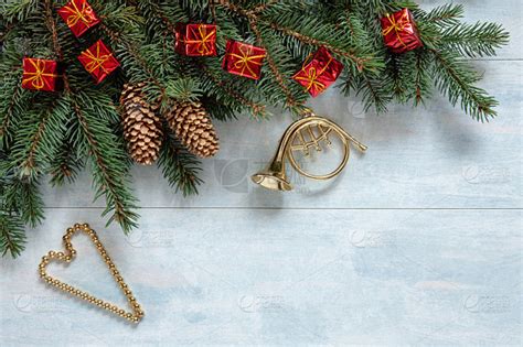 圣诞背景用冷杉树枝、松果、金色喇叭和圣诞心形装饰。圣诞节和新年的概念。特写，俯视图浅蓝色木制桌子