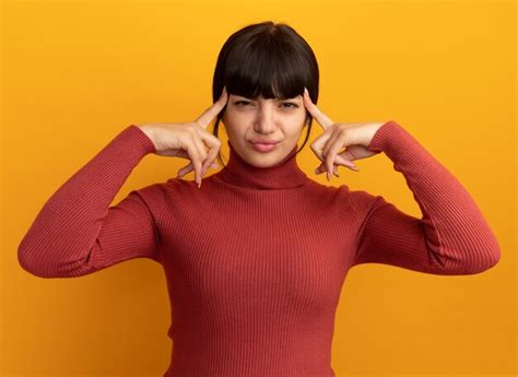Недовольная молодая брюнетка кавказской девушки кладет пальцы на виски
