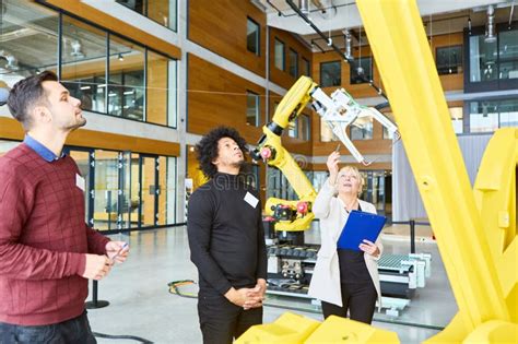 team of engineers programming a robotic arm in a modern industrial
