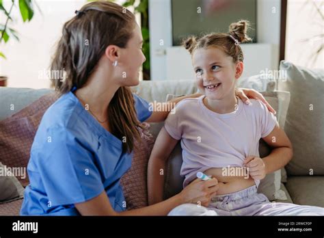 Nurse Applying A Continuous Glucose Monitor Sensor To The Arm Of A