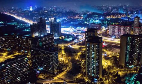 An Aerial View Of A City At Night With Lots Of Tall Buildings And Street Lights