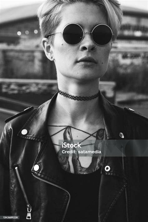 Portrait Of Young Daring Woman In Round Glasses And Leather Jacket