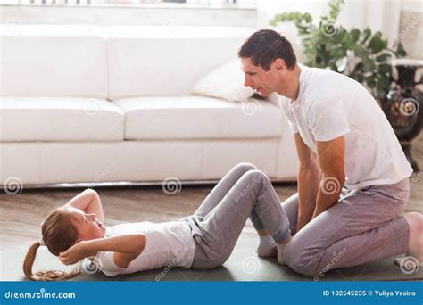Young Father And His Cute Little Daughter Have Abs Workout At Home