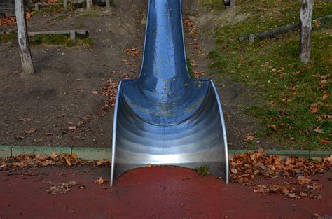 잔디 언덕과 나무 팔리세이드가있는 필드에 스테인레스 스틸 슬라이드 타탄 고무 패드에 영향을 미치는 어린이를 슬라이딩하기위한 대형