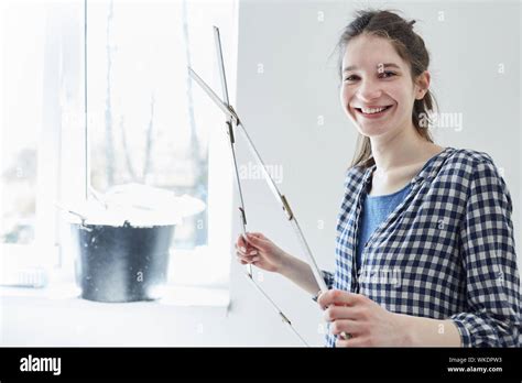 Happy Young Woman As A Handyman With Folding Rule While Renovating Her