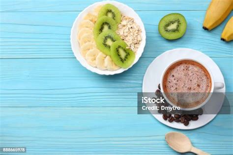 오트밀 죽 커피 컵과 푸른 나무 배경에 과일 아침 식사 키 위와 바나나 오트밀 건강 한 아침 식사 개념입니다 상위 뷰 0명에
