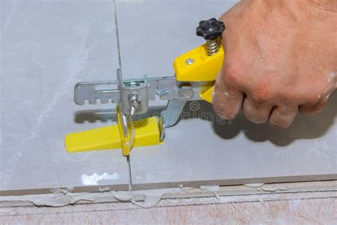 Working On Tile Leveling With Plastic Clips And Wedges In A Bathroom