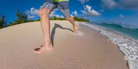 Low Angle Unrecognizable Male Tourist Runs Barefoot Along The Tropical