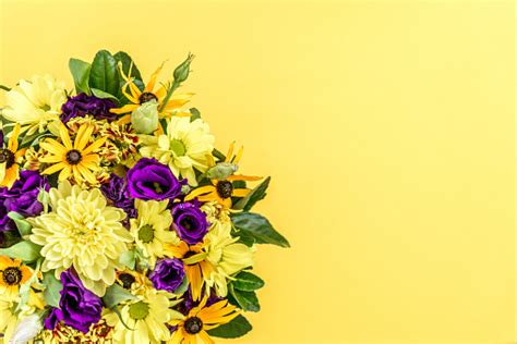 밝은 노란색 배경에 고립 된 세련된 화려한 아름다운 봄 꽃다발 밝은 신선한 보라색과 노란색 꽃입니다 생일에 휴일 장식 구성