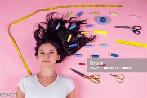 여성 재봉사 재단사 는 여러 가지 색의 실 재봉틀과 측정 테이프 핑크 배경 스튜디오가있는 바닥에 새로운 옷 컬렉션을 꿈꾸고 생각합니다 25 29세에 대한 스톡 사진 및 기타