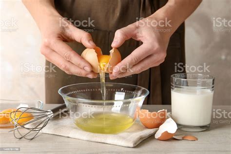 밝은 나무 테이블에서 유리 그릇 위에 흰색에서 달걀 노른자를 분리하는 여성 클로즈업 갈색에 대한 스톡 사진 및 기타 이미지