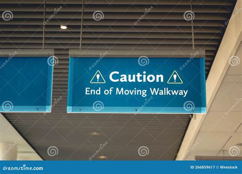 Hanging Blue Cation Sign Warning The End Of A Moving Walkway Stock