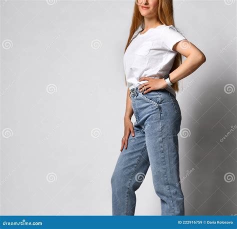 Giovane Sconosciuta Magra Vestita Di Elegante Jeans Blu E Scarpe Da Ginnastica Bianche Immagine