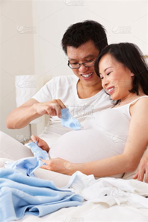 一对亚洲夫妇为胎儿打袜子