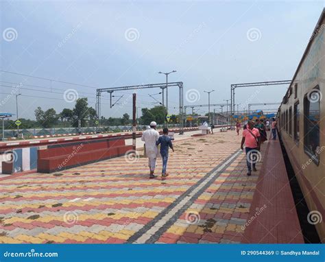 A Train Is Stationed On A Railway Platform In Small City Station In