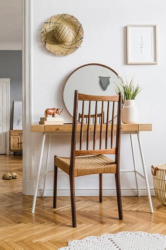 나무 책상 의자 Commode 거울 식물 포스터 프레임 책과 우아한 액세서리를 갖춘 거실의 세련되고 디자인 된 홈 인테리어 세련된 홈 장식 템플릿 밝은 열린 공간 디자인에