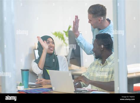 Business People Giving High Five While Working Together At Desk In A
