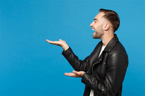 파란색 벽 배경 스튜디오 초상화에 고립 된 작업 영역에 표시 하는 검은 자 켓 흰색 T 셔츠에 잘생긴 세련 된 젊은 이루어지지 남자 사람들은 진심으로 감정 라이프 스타일