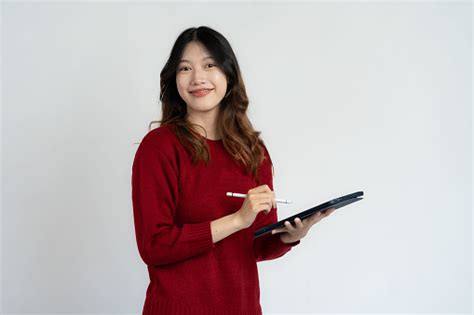 하얀 배경에 웃고 있는 인터넷 서핑을 하는 태블릿 디지털 태블릿을 들고 있는 젊은 아름 다운 아시아 여성 가리키기에 대한 스톡