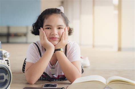 Premium Photo Portrait Of Girl With Book Relaxing On Hardwood Floor
