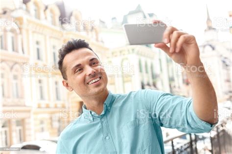 순간을 포착합니다 젊은 남자 서 에 도시 거리 복용 셀카 에 스마트 폰 찾고 카메라 쾌활한 클로즈업 갈색 머리에 대한 스톡 사진