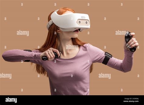 Casual Ginger Haired Woman In Purple Pullower Wearing Vr Headset And