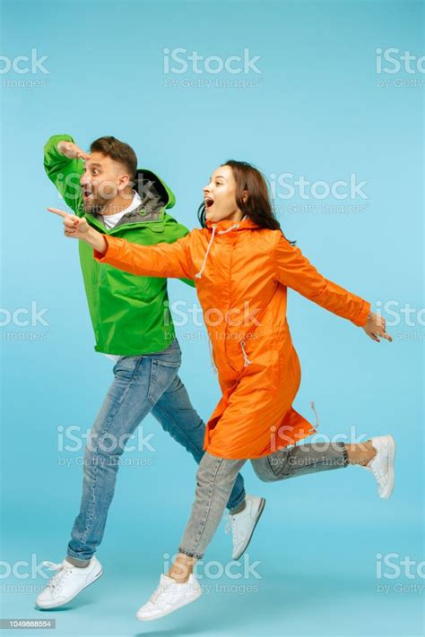Couplel 블루에 고립 된가 자 켓에 스튜디오에서 포즈를 놀라게 하는 젊은 스튜디오 촬영에 대한 스톡 사진 및 기타 이미지