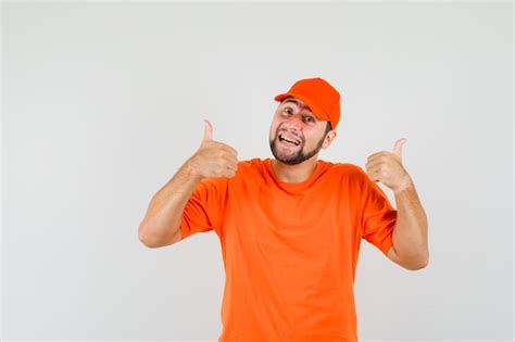 Free Photo Delivery Man In Orange T Shirt Cap Showing Double Thumbs