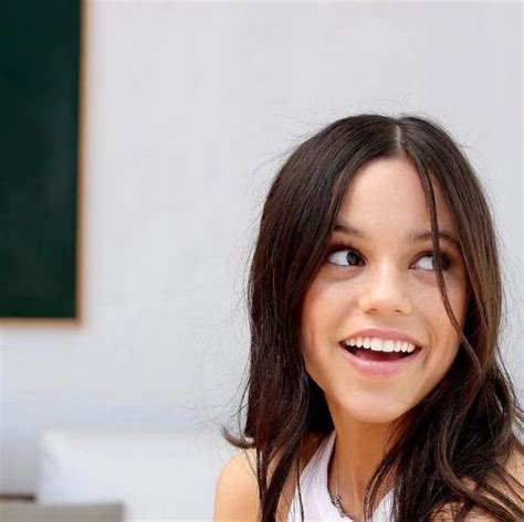 A Woman With Long Hair Smiling At The Camera
