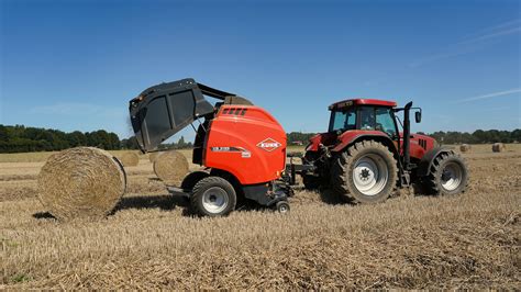 Red Tractor Pulling A Round Baler In A Field Photo Free Deutschland Image On Unsplash