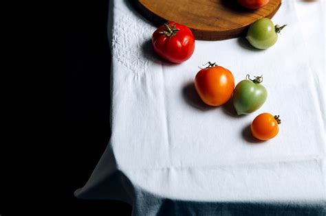 백색 섬유 배경에 서로 다른 색상의 신선한 유기농 토마토 추수 개념입니다 가로 구성입니다 오버 헤드 보기 자연 조명 공간에 복사