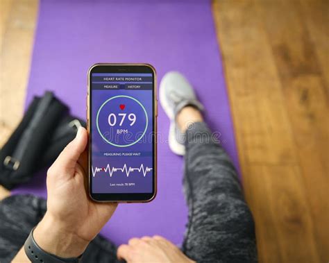 Close Up Of Woman About To Exercise Looking At Heart Rate App On Mobile