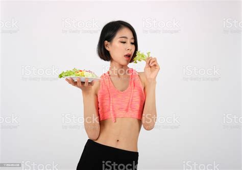 運動健身婦女在運動服與蔬菜沙拉的白色背景健康運動 照片檔及更多 一個人 照片 一個人 人 休閒活動 主題 Istock