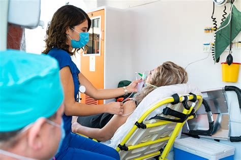 전염병 중 구급차에서 호흡기 환자를 돕는 얼굴 마스크를 가진 여성 간호사 구급대원 25 29세에 대한 스톡 사진 및 기타 이미지